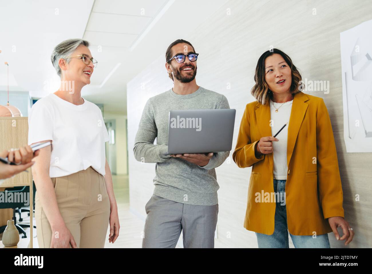Group of diverse designers smiling cheerfully during a meeting in a ... Group of diverse designers smiling cheerfully during a meeting in a ...