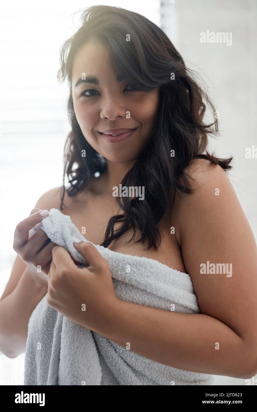 Its amazing how good you can feel after a shower. Portrait of an attractive young woman wrapped ...