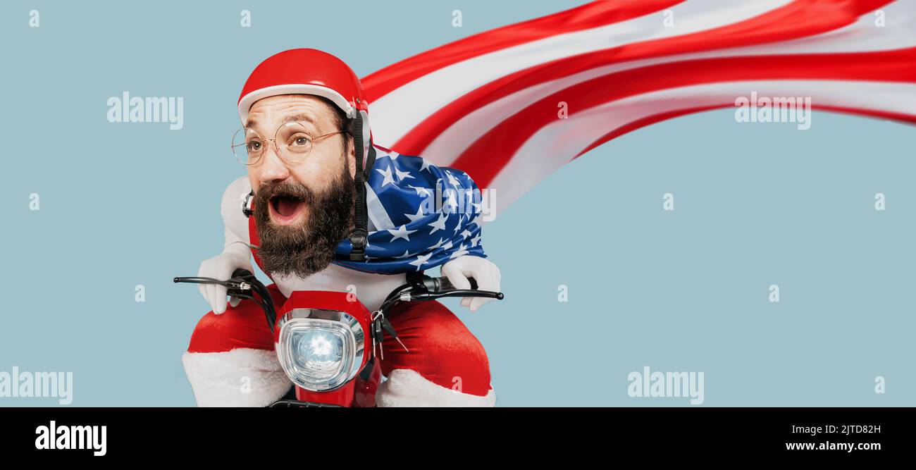 Santa with a large usa flag in the form of a raincoat rides at high ...