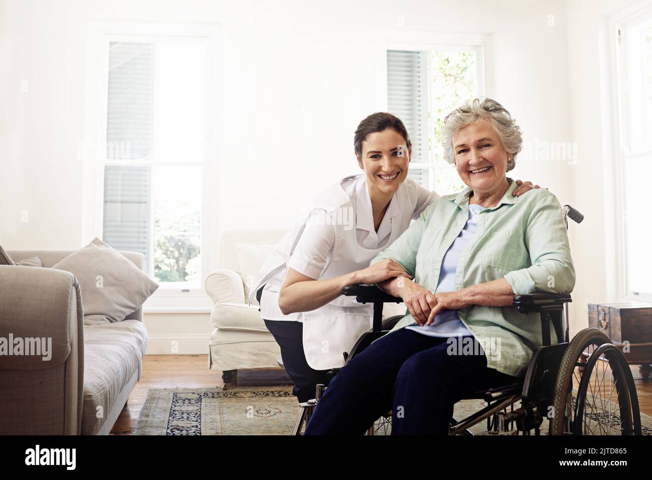 Support with a smile. Portrait of a smiling caregiver and a senior ...
