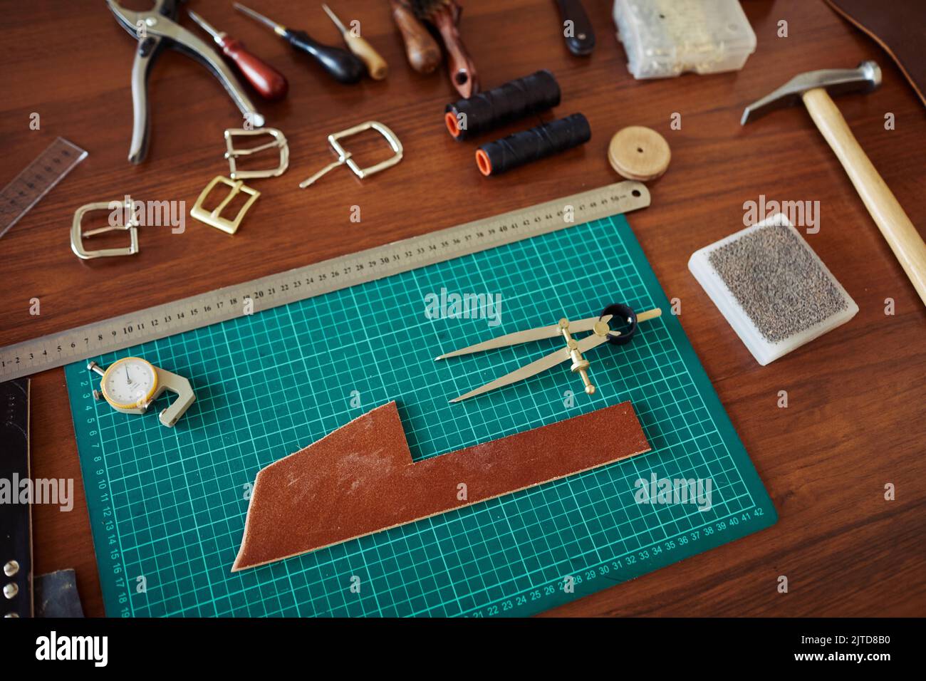 Leatherworking station with various tools on wooden table, copy space ...