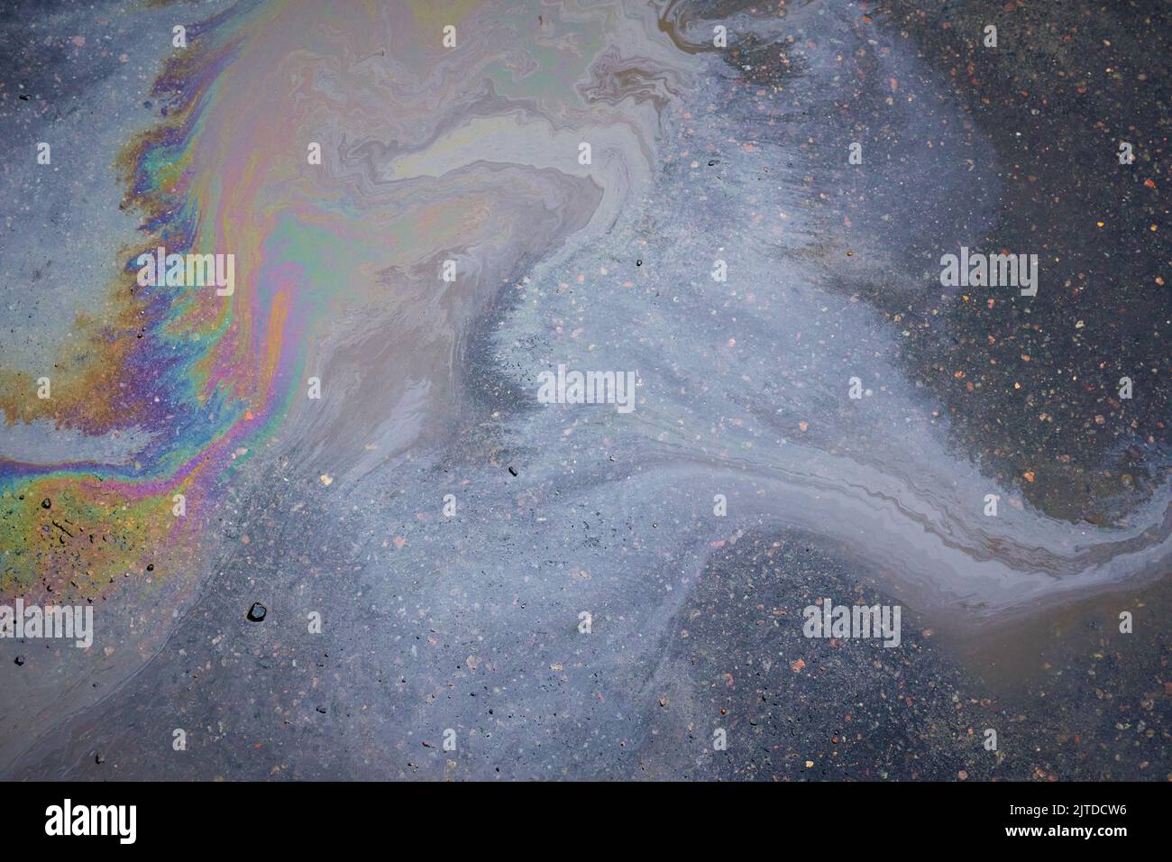Oil stain on the asphalt, rainbow-shaped colored gasoline stains on an ...