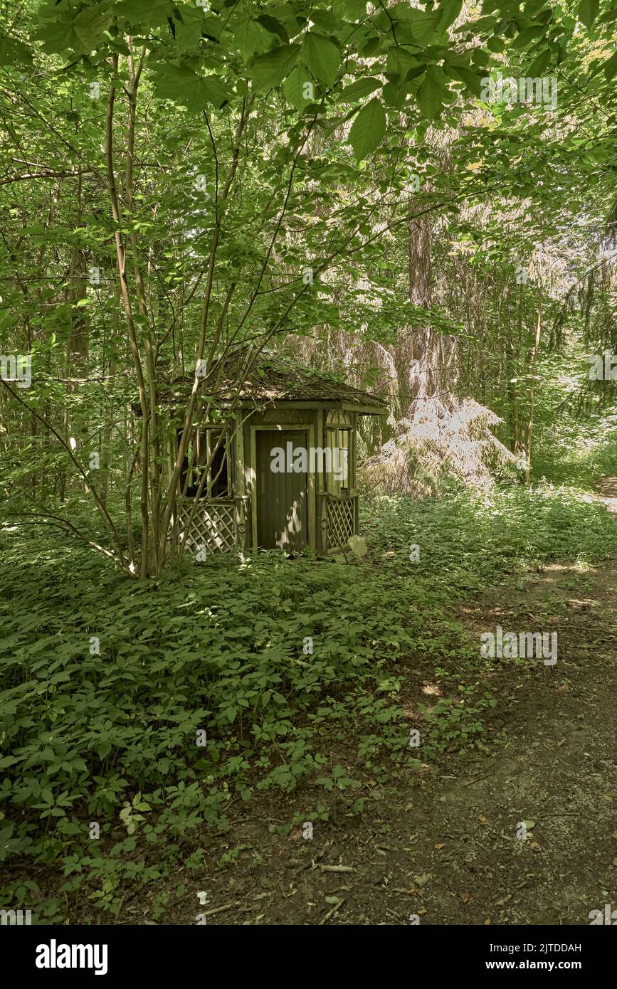Summer cloudy day. There is an old dilapidated summer gazebo in the ...