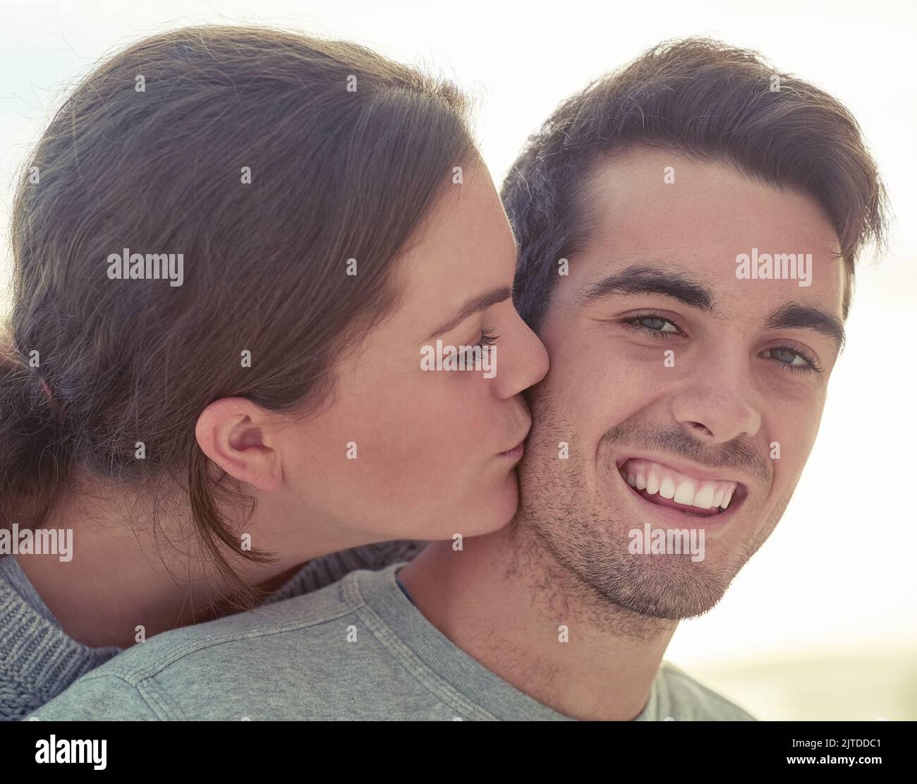 Kisses for her sweetheart. a young woman kissing her boyfriend on the ...