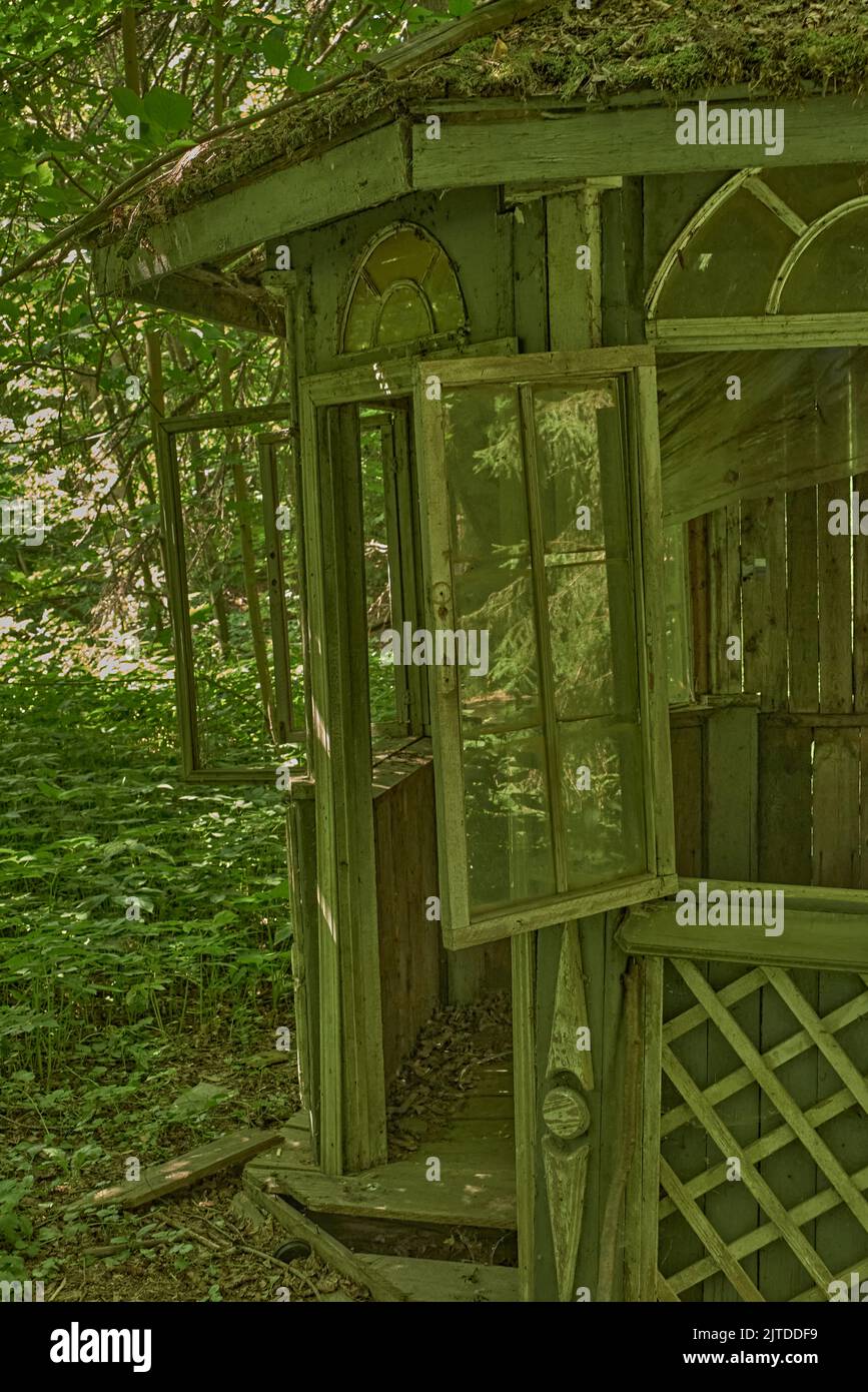 Summer cloudy day. There is an old dilapidated summer gazebo in the ...