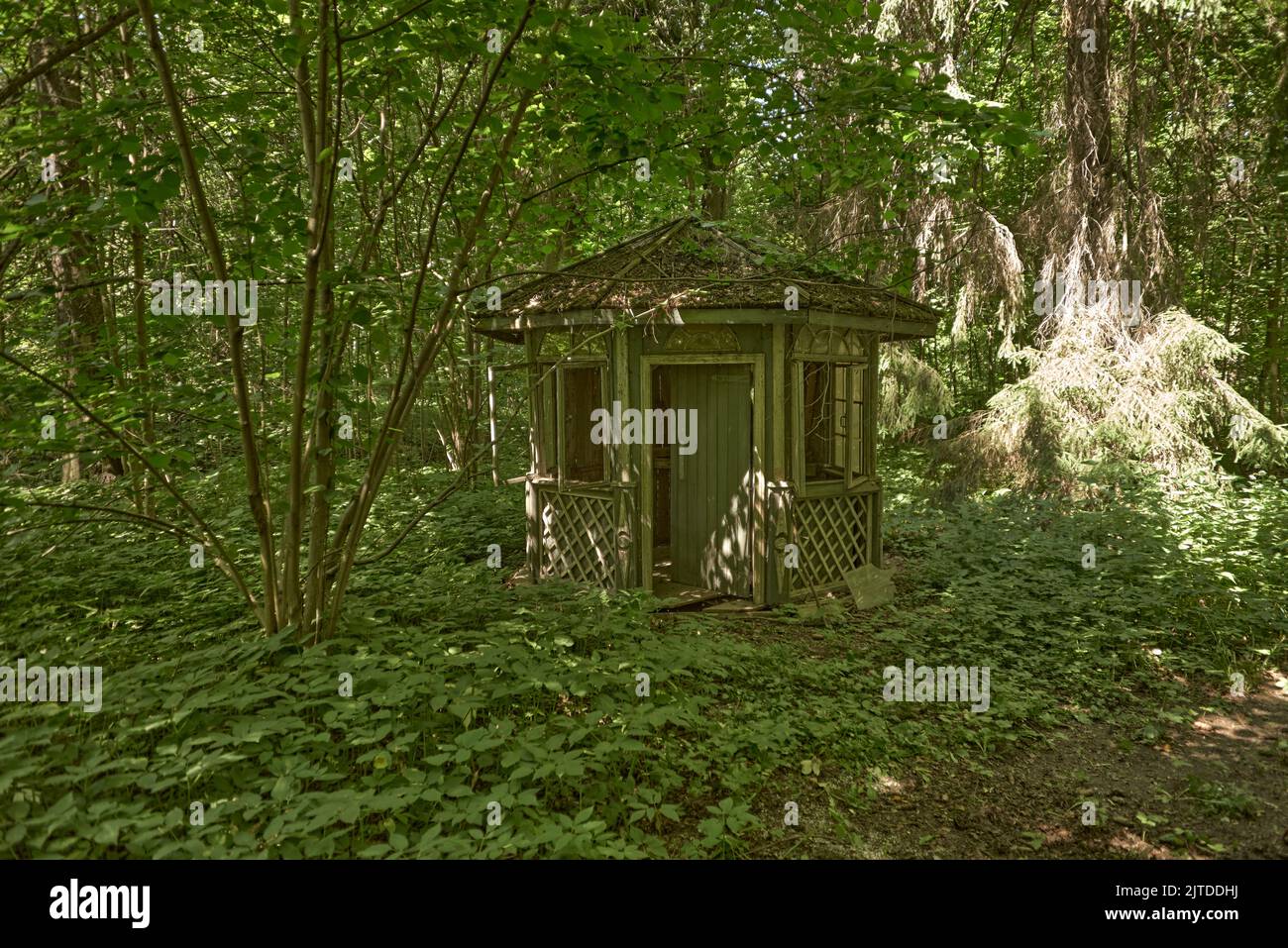 Summer cloudy day. There is an old dilapidated summer gazebo in the ...