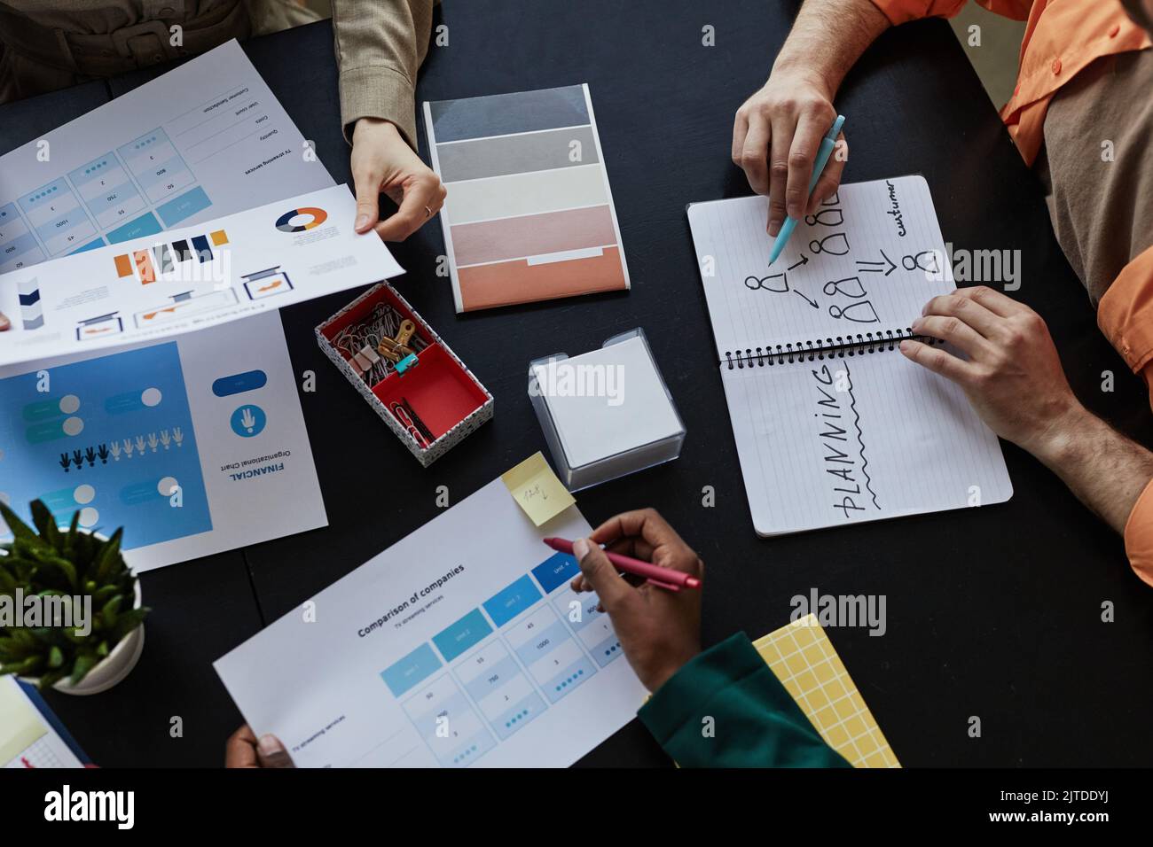 Top down view at table with documents and diverse team planning design ...