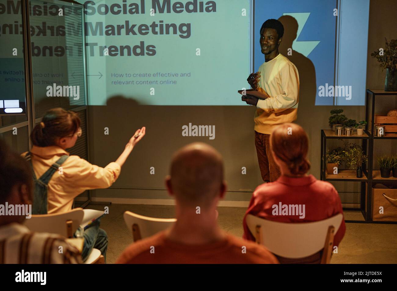 Portrait of young black man giving presentation on marketing to team ...