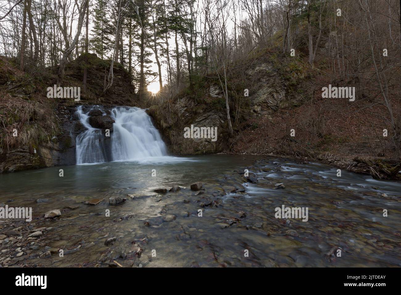 A waterfall in the mountains is an untouched corner of wild nature. A ...