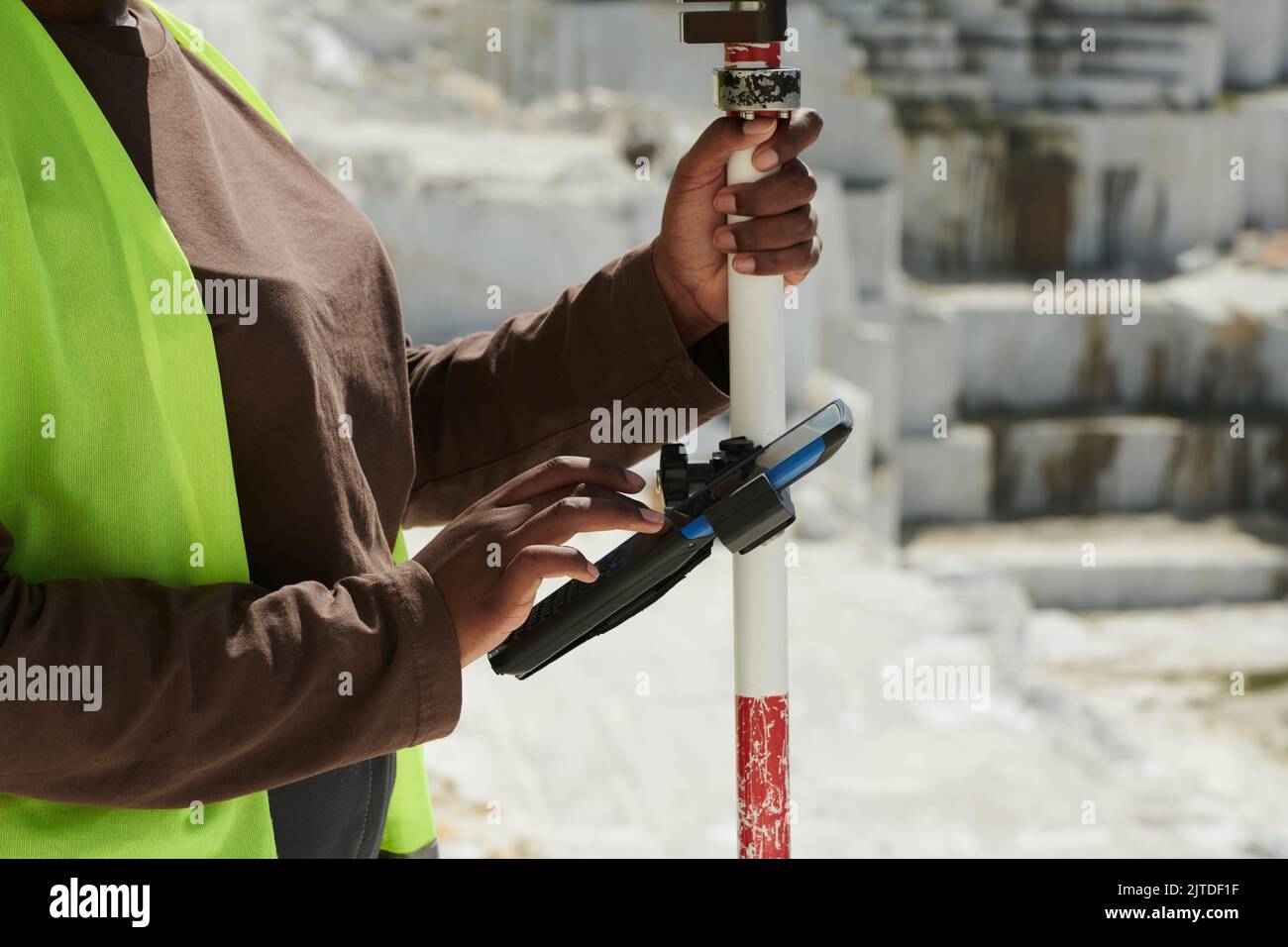 Hands of young black female worker of marble quarry scrolling through ...