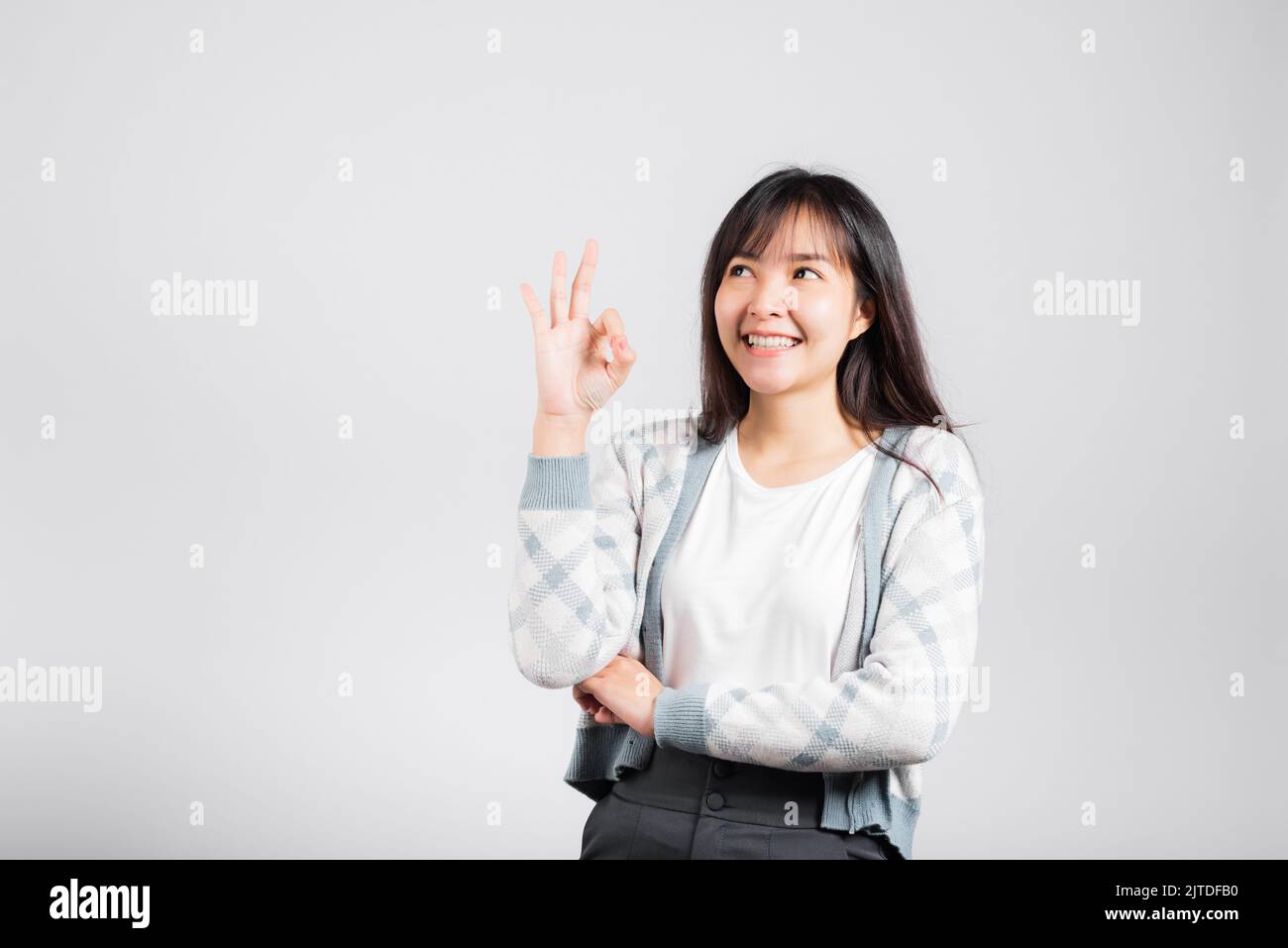 Woman smiling showing made finger OK symbol sign to agree studio shot ...