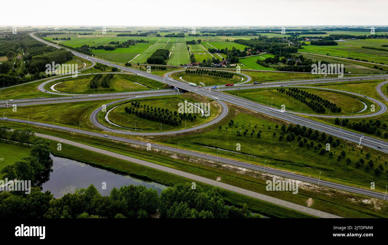 An aerial view of highway interchange and overpass with green woods in ...