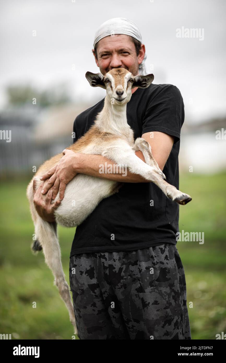 local agriculture, farmer's day 12 october. a man with a goat in his ...