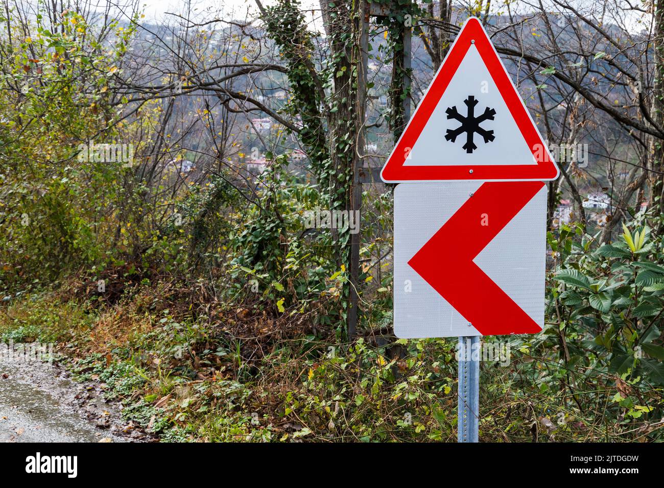Left turn direction and Risk of Ice, red and white road signs mounted ...