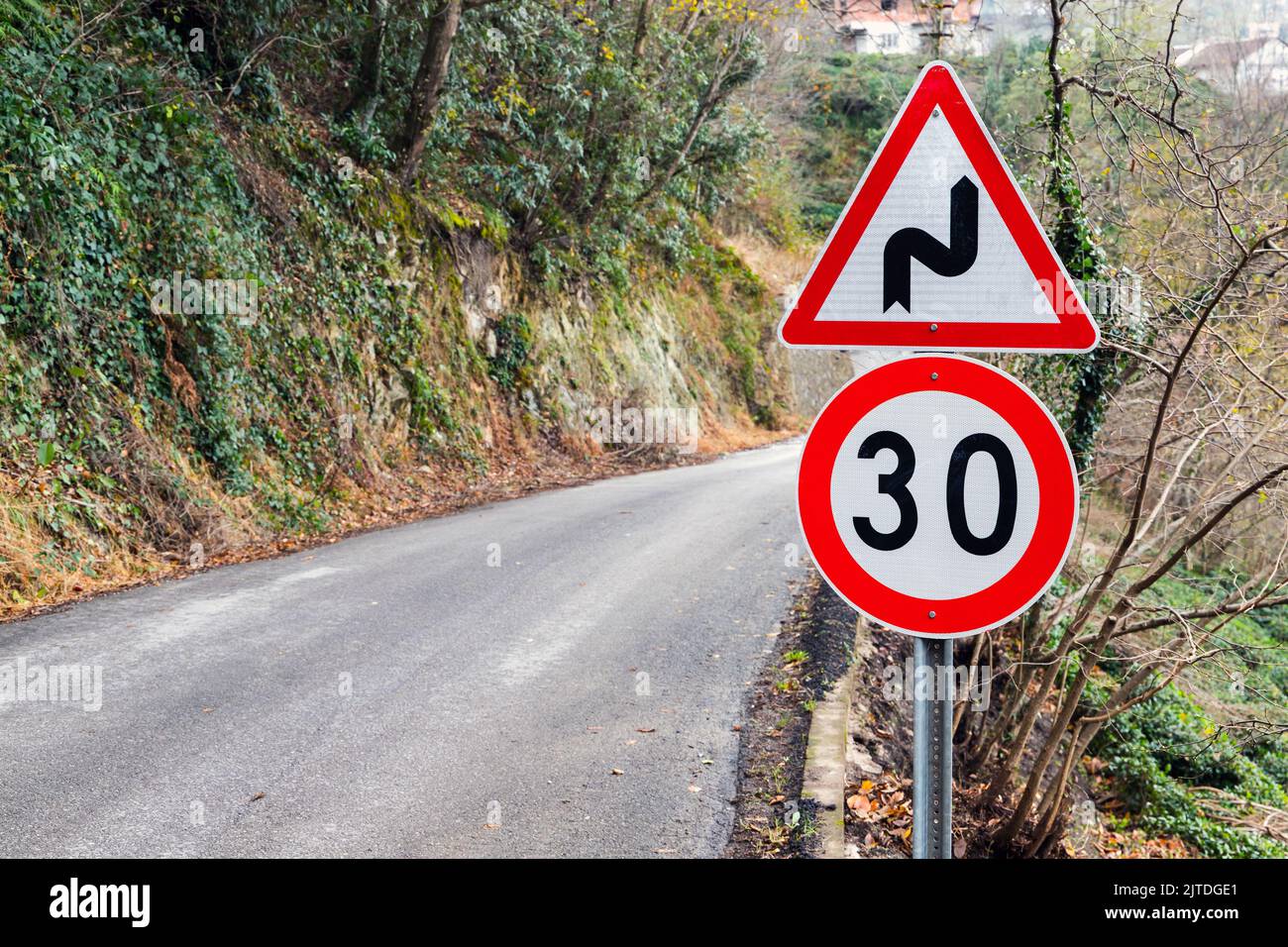 Dangerous turns and speed limit road signs mounted near turning ...