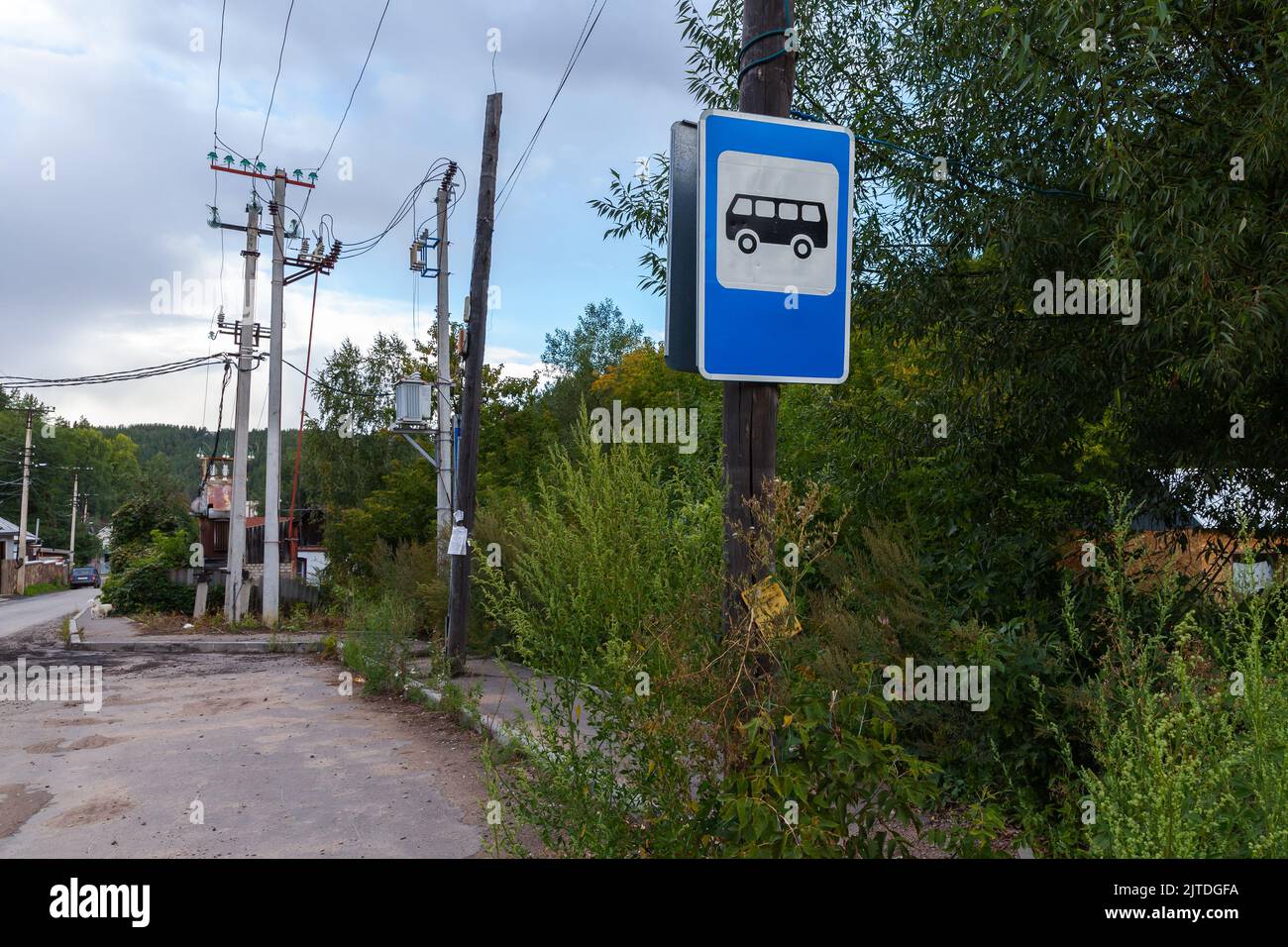 Empty bus stop with blue road sign, rural public transportation ...