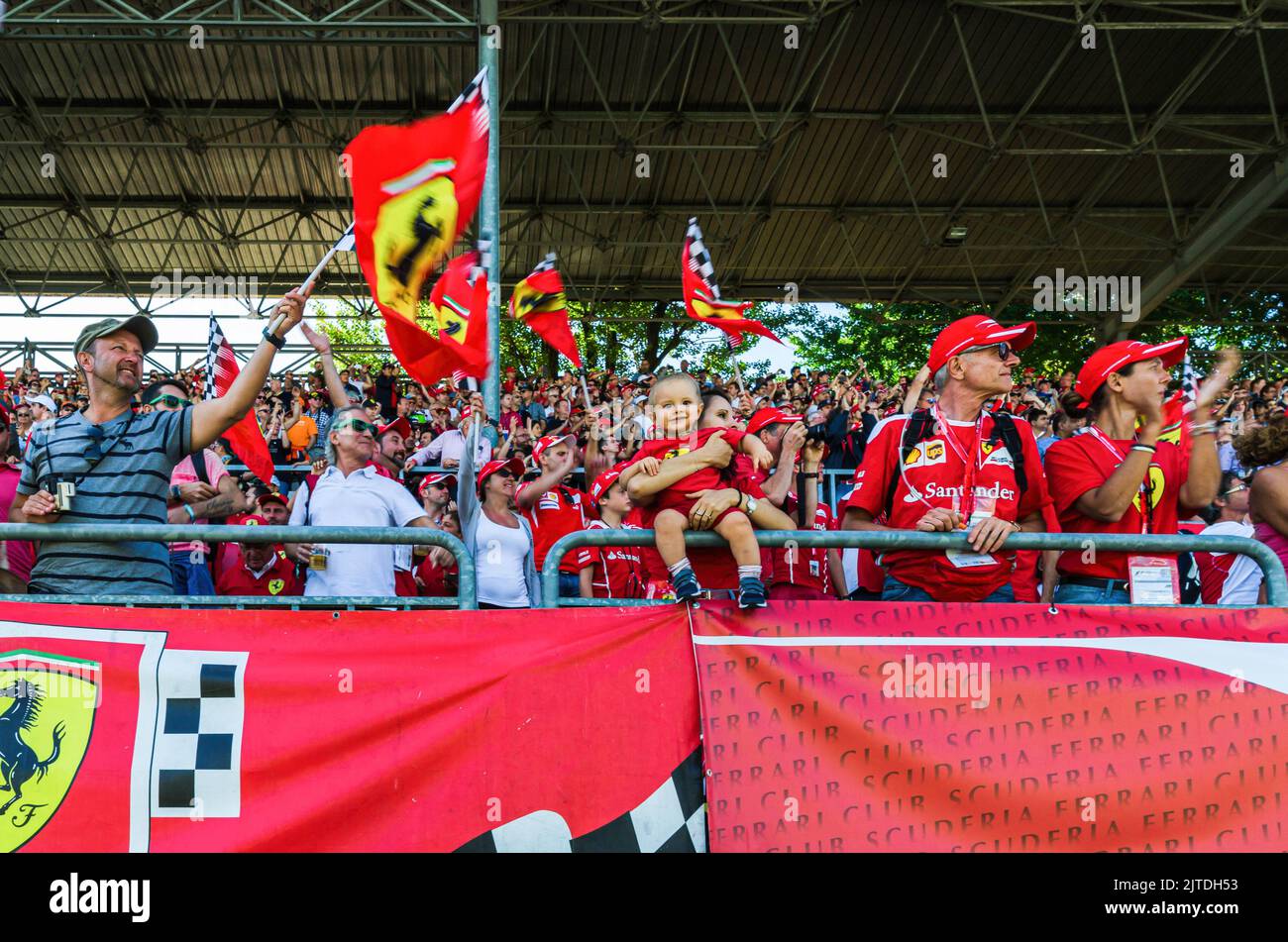 A baby is seen surrounded by Scuderia Ferrari flags in the grandstand ...