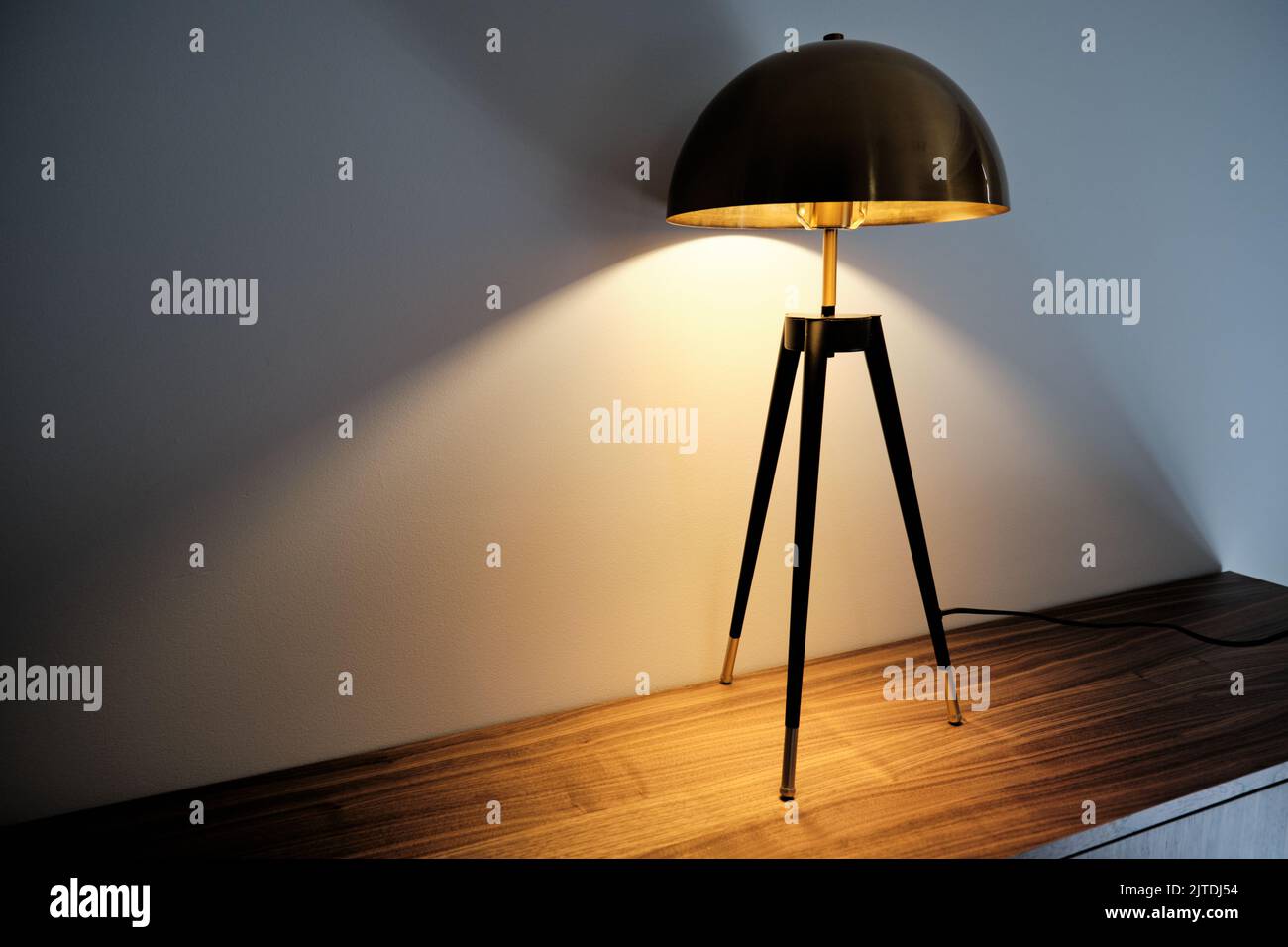 A luxury brass table lamp on a cabinet at night Stock Photo - Alamy