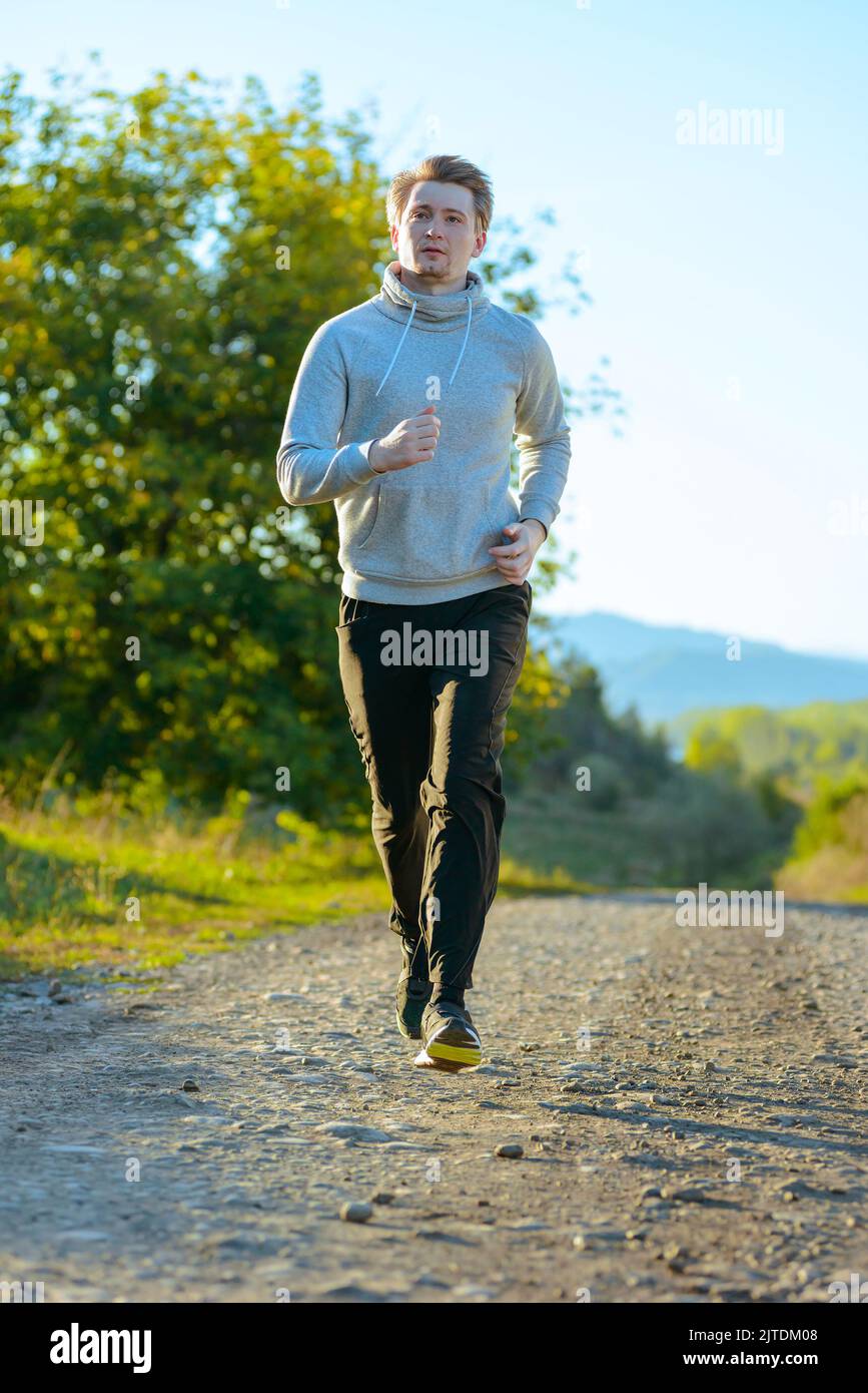 Running man jogging in rural nature at beautiful summer day. Sport ...
