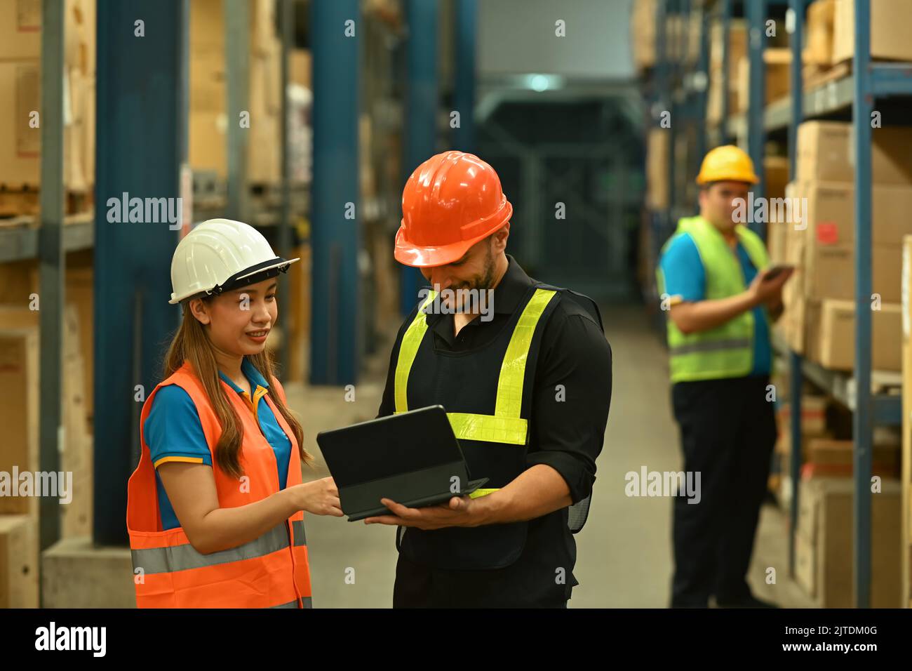 Male managers and warehouse worker checking inventory in a warehouse ...