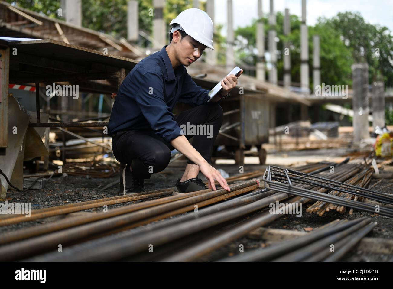 Young male inspectors wearing safety helmet check the quality of steel ...