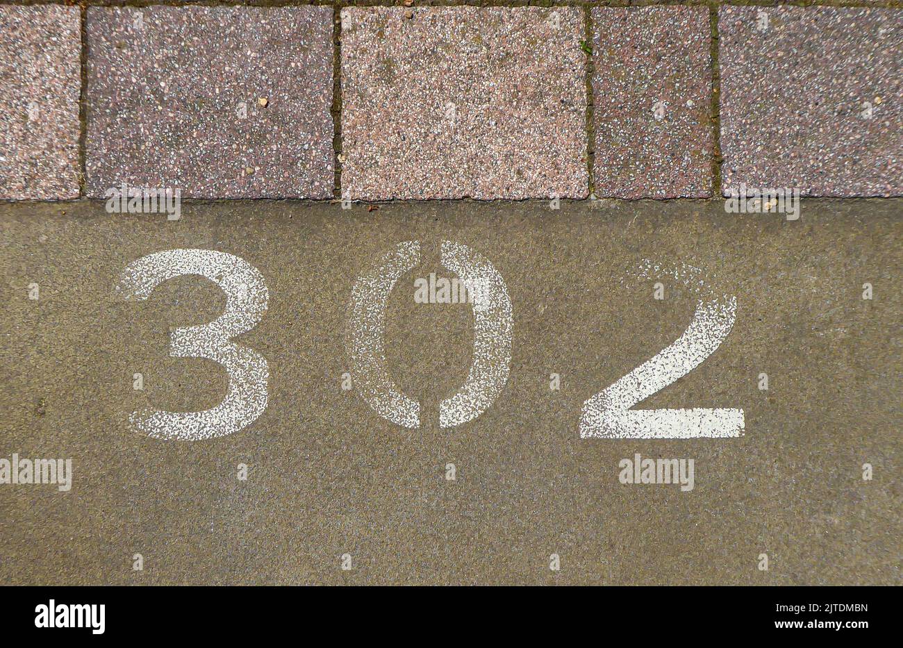 Detail of a painted number on a parking lot with paved parking area ...