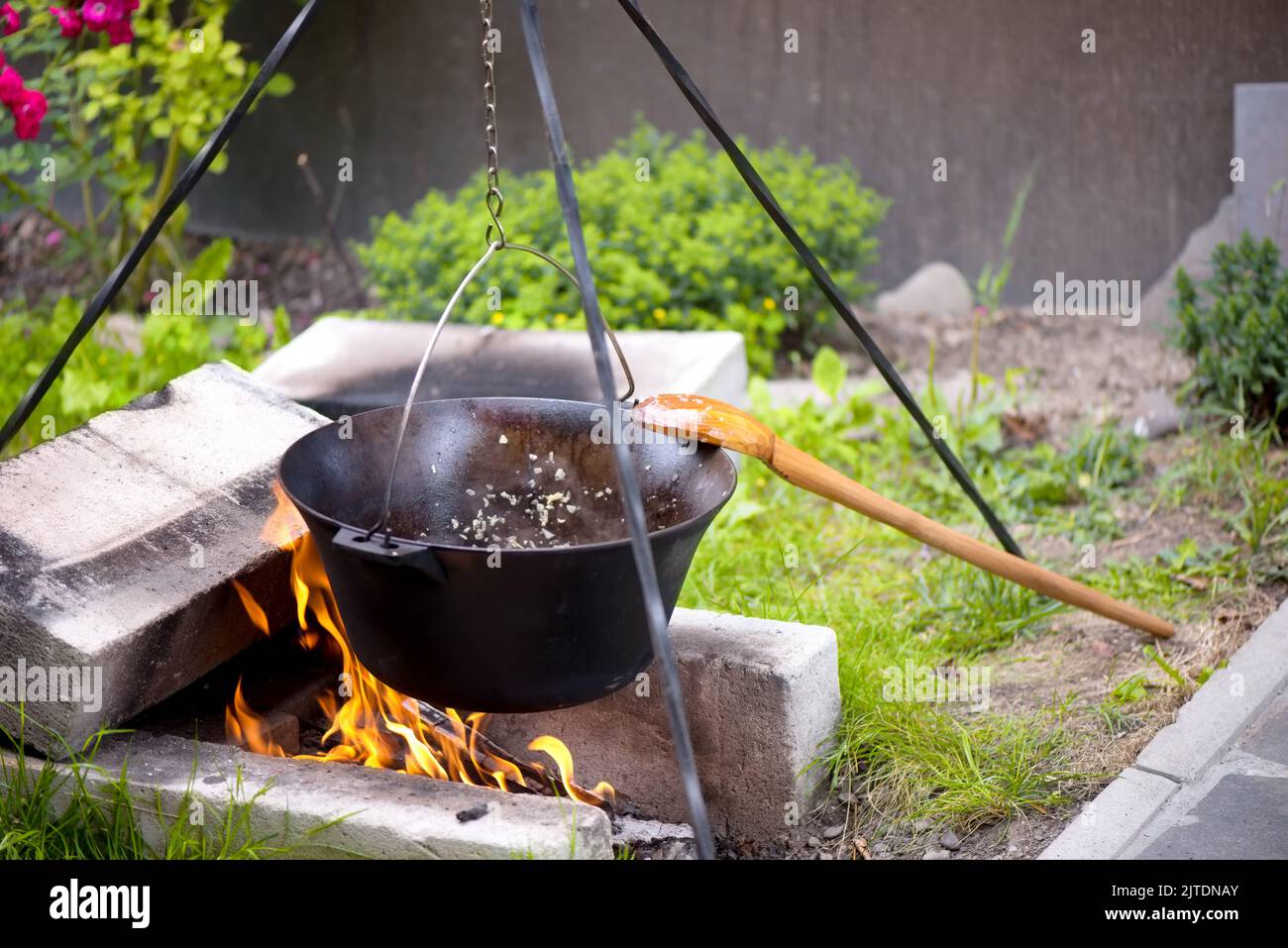Big wooden spoon and a cauldron on fire Stock Photo - Alamy