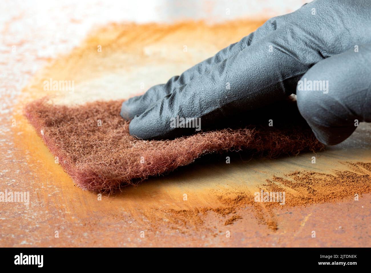 Rubbing rust off sheet steel with an abrasive pad. Restoration project ...