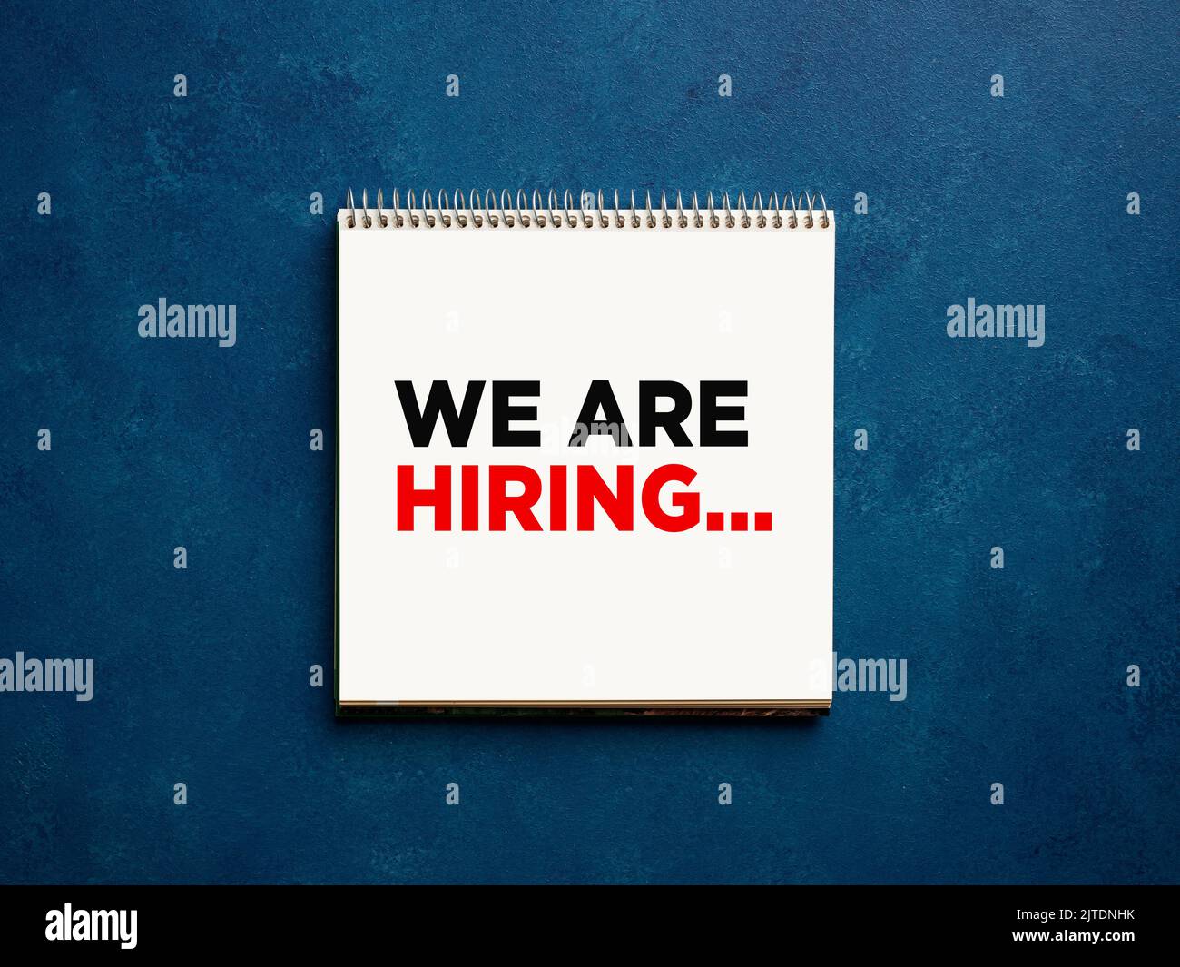 The message we are hiring on a notebook on blue business office desktop ...