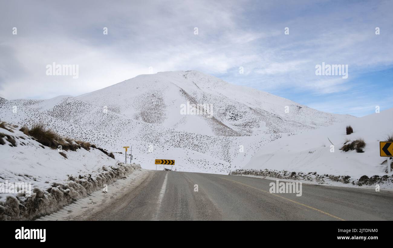 Road to Lindis Pass in winter, mountains covered in snow. South Island ...
