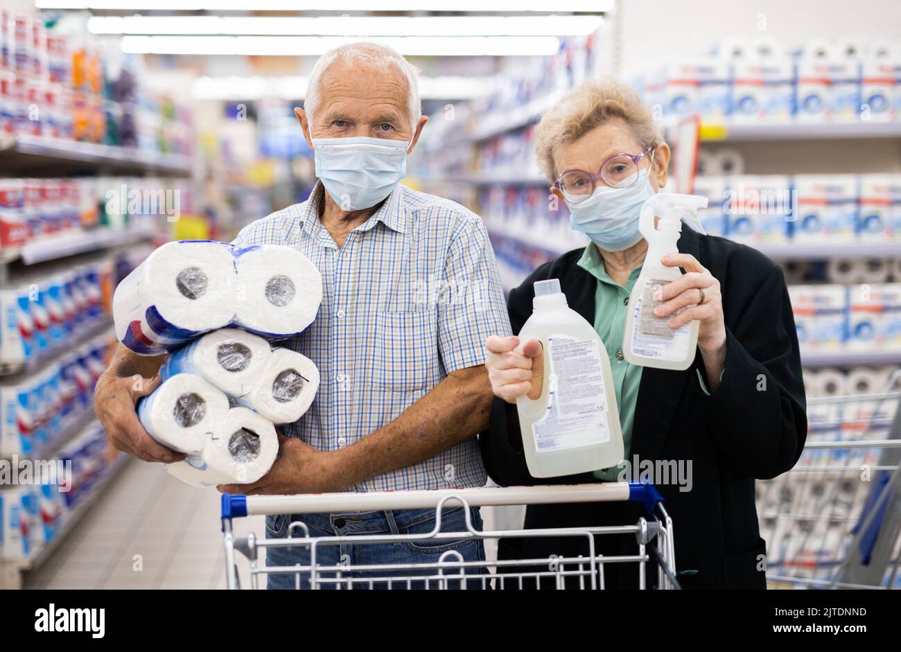 mature couple wearing mask and gloves with covid protection picks paper ...
