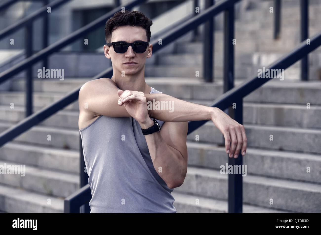 Focused serious athlete warming up and stretching muscles Stock Photo ...