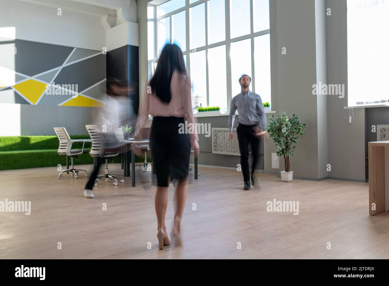Long-haired woman walking in the office to the window Stock Photo - Alamy