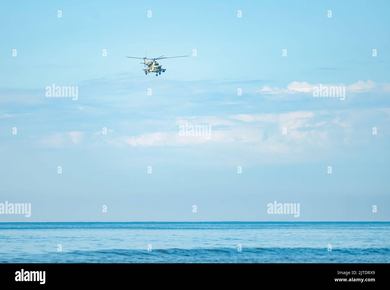 Military helicopter flying overhead on a clear day above the sea ...