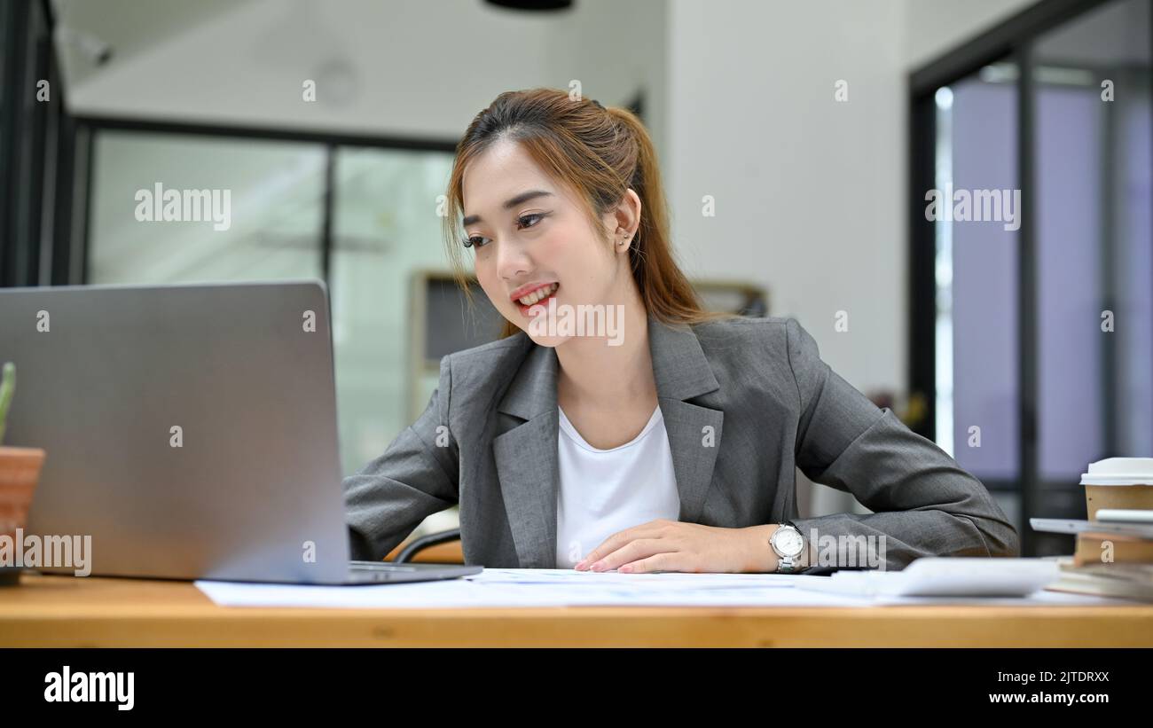 Charming and beautiful young Asian businesswoman or female financial ...