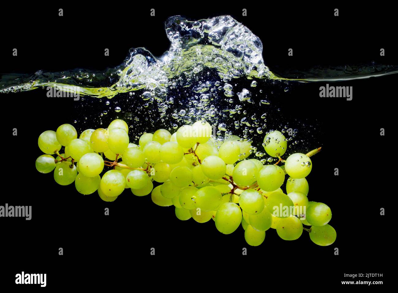 Bunch of white grapes splashing underwater isolated on black background ...