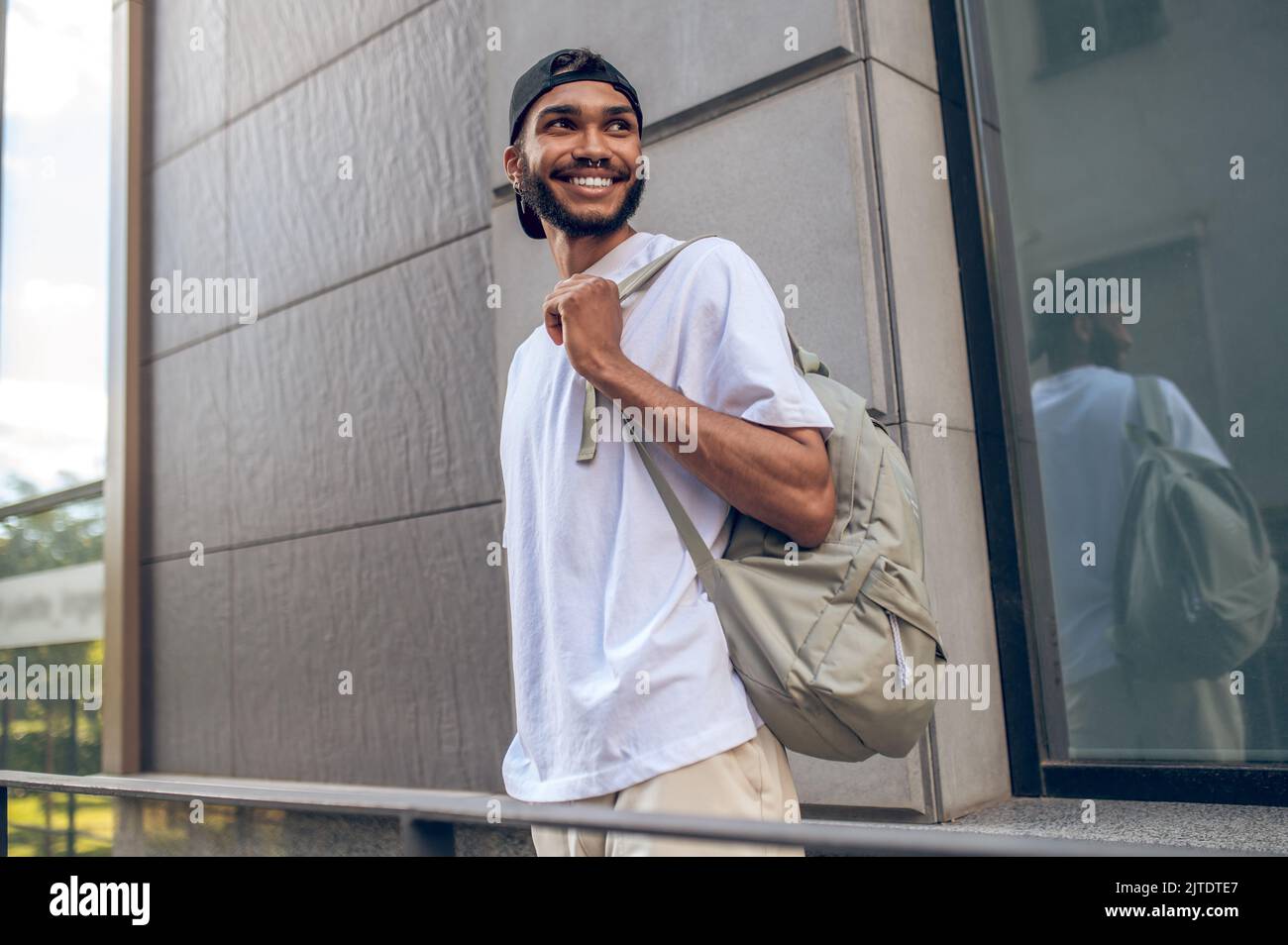 A handsome smiling man with a backpack in the city street Stock Photo ...