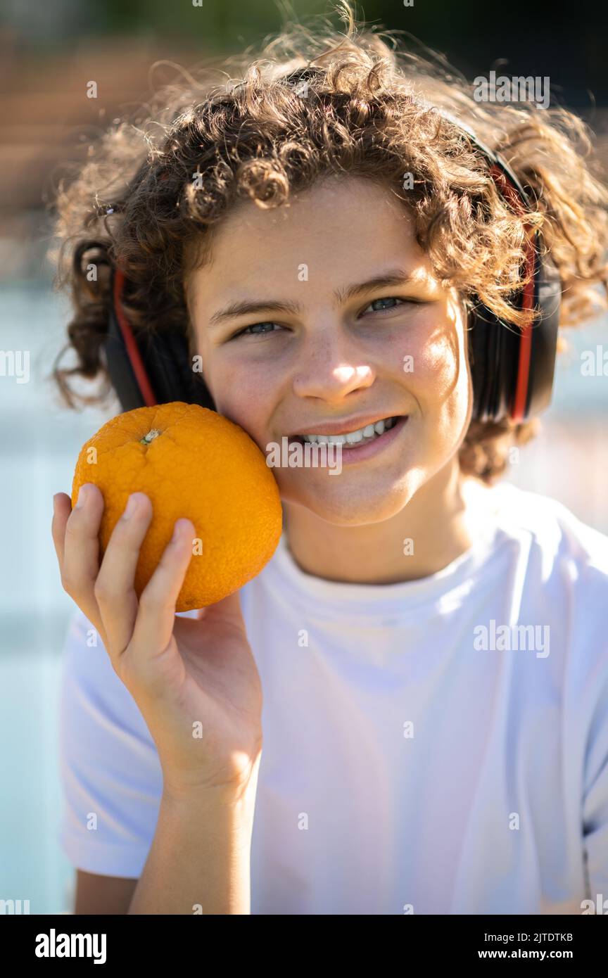 Teenager posing for the camera with his favorite citrus fruit Stock ...