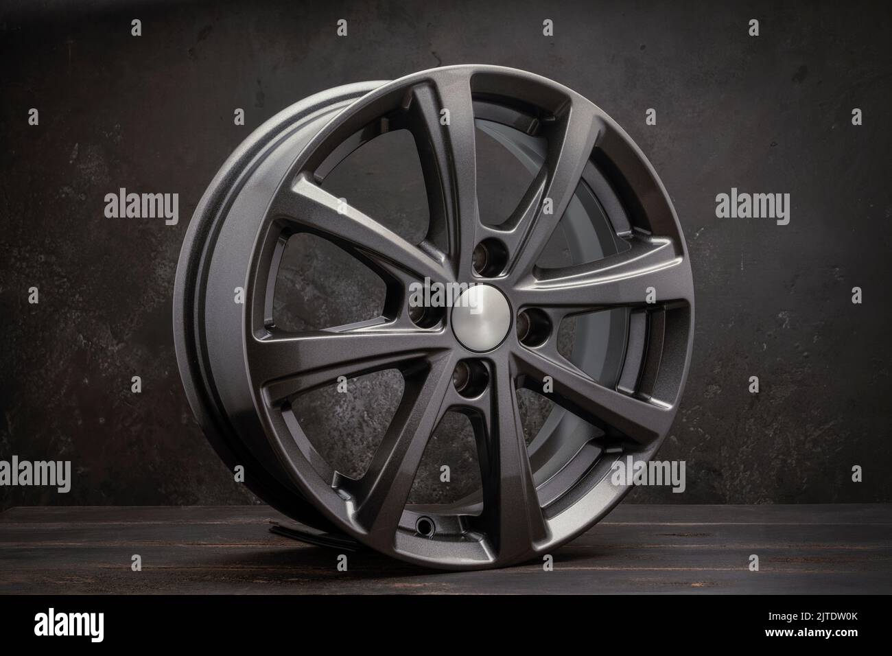 new grey allonew grey alloy wheels on a dark textured black background ...