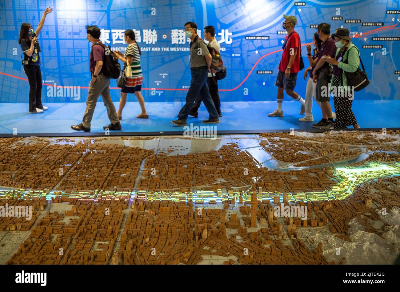 Taipei. 30th Aug, 2022. Visitors walk past a model of the city in ...