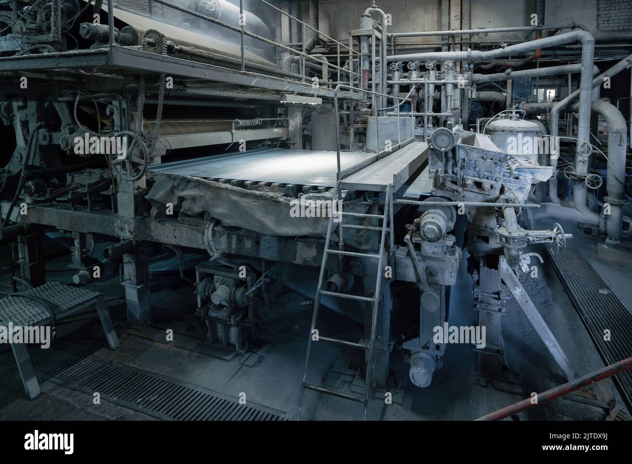 Production machine with rolls of new paper in waste paper recycling ...