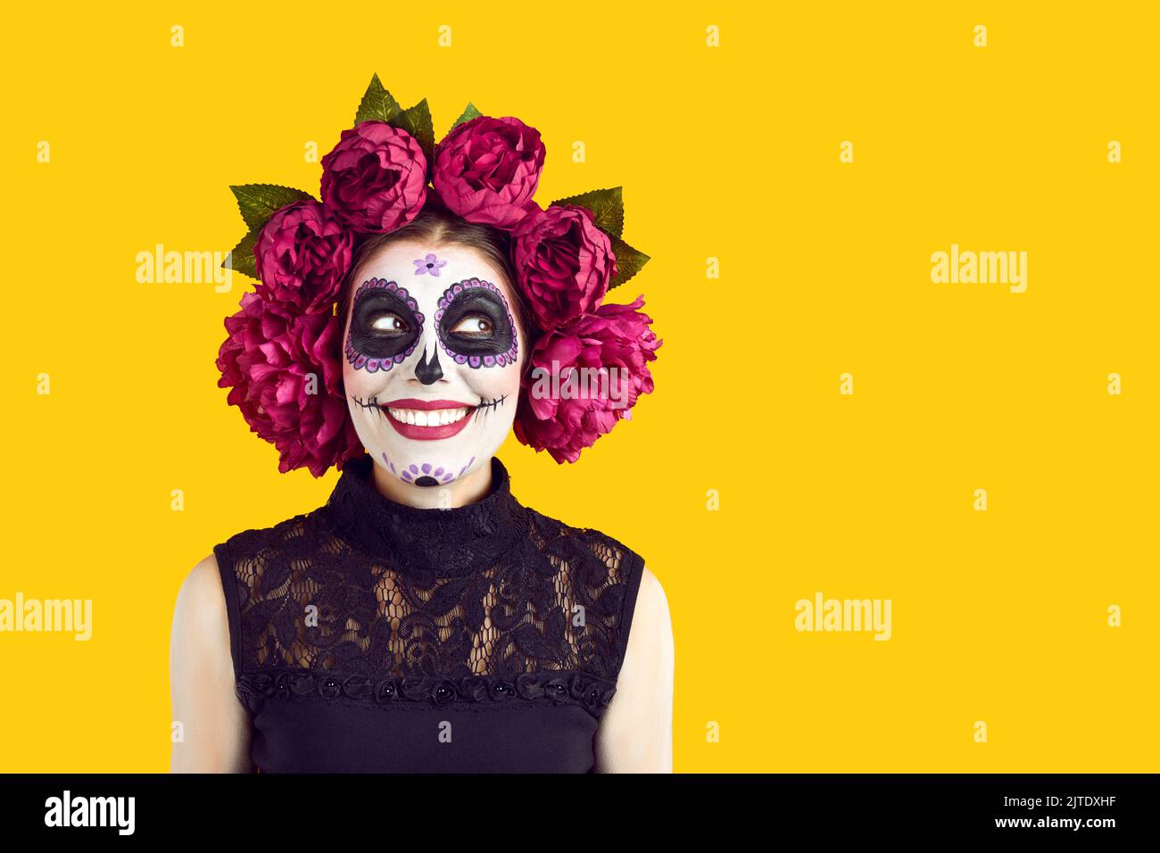 Happy woman dressed for Halloween or Day of the Dead looking at yellow ...