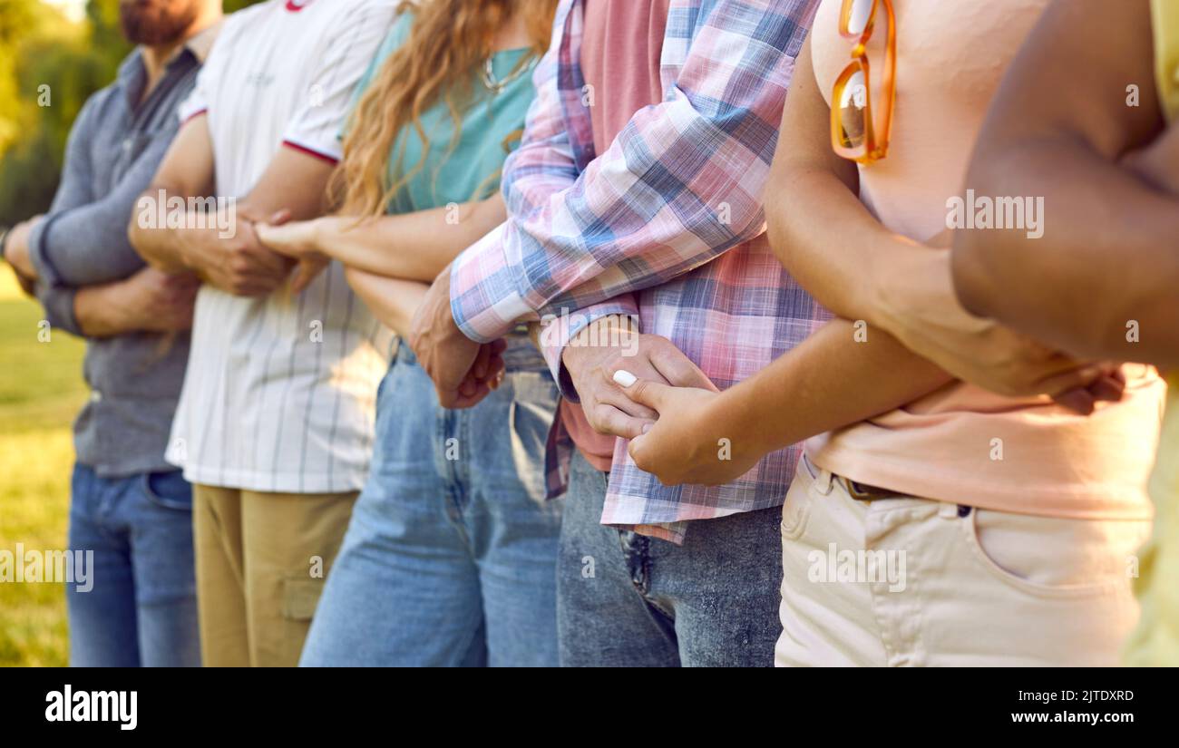 Multiracial people men and woman hold hands as sign of friendship or ...