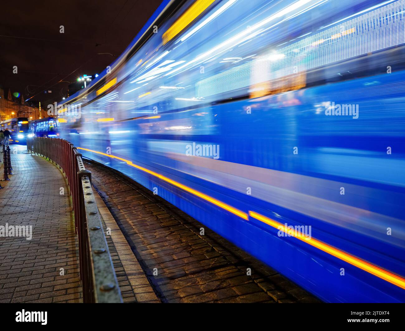 city tram departure from tram station in the night city. urban public ...