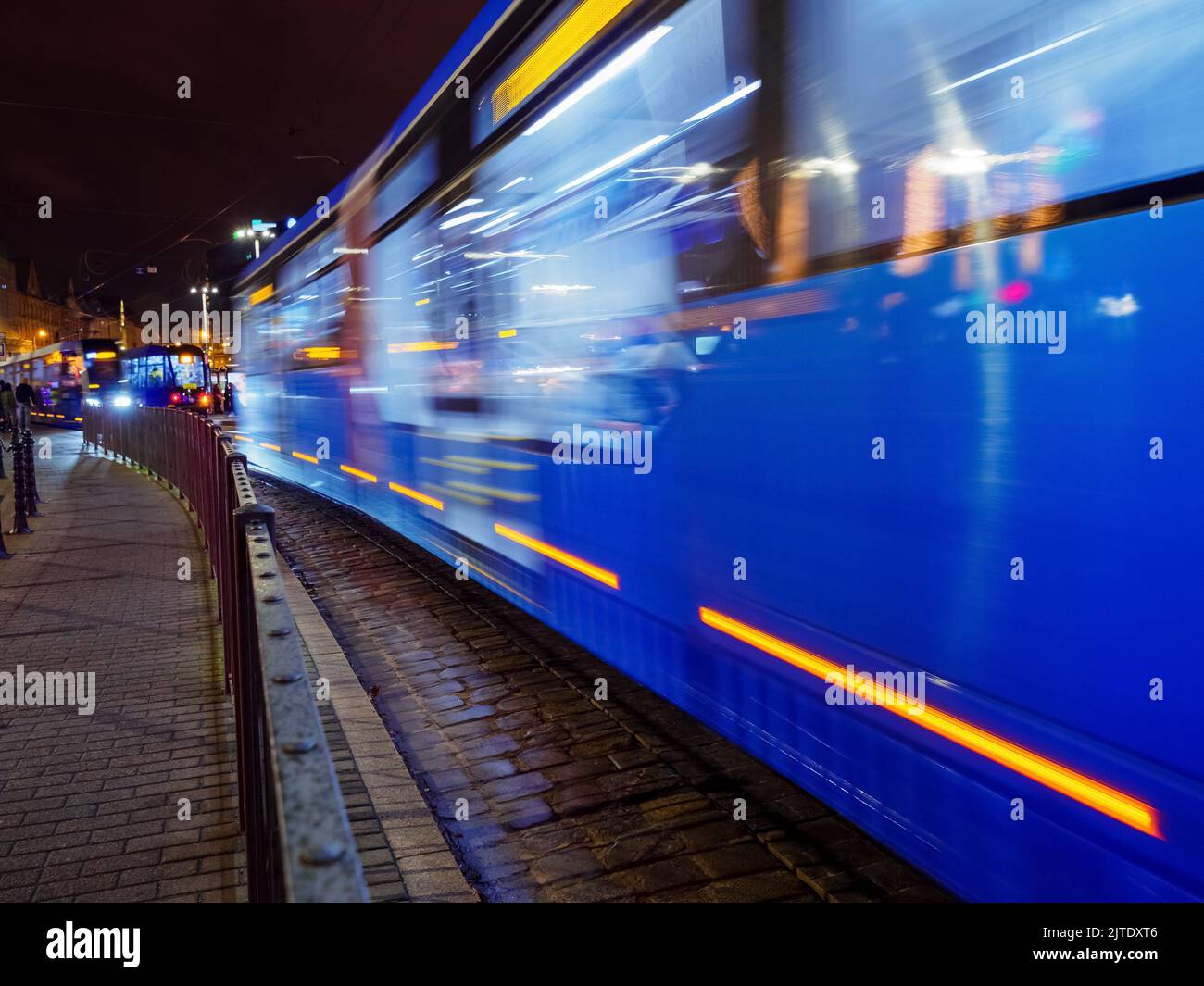 city tram departure from tram station in the night city. urban public ...