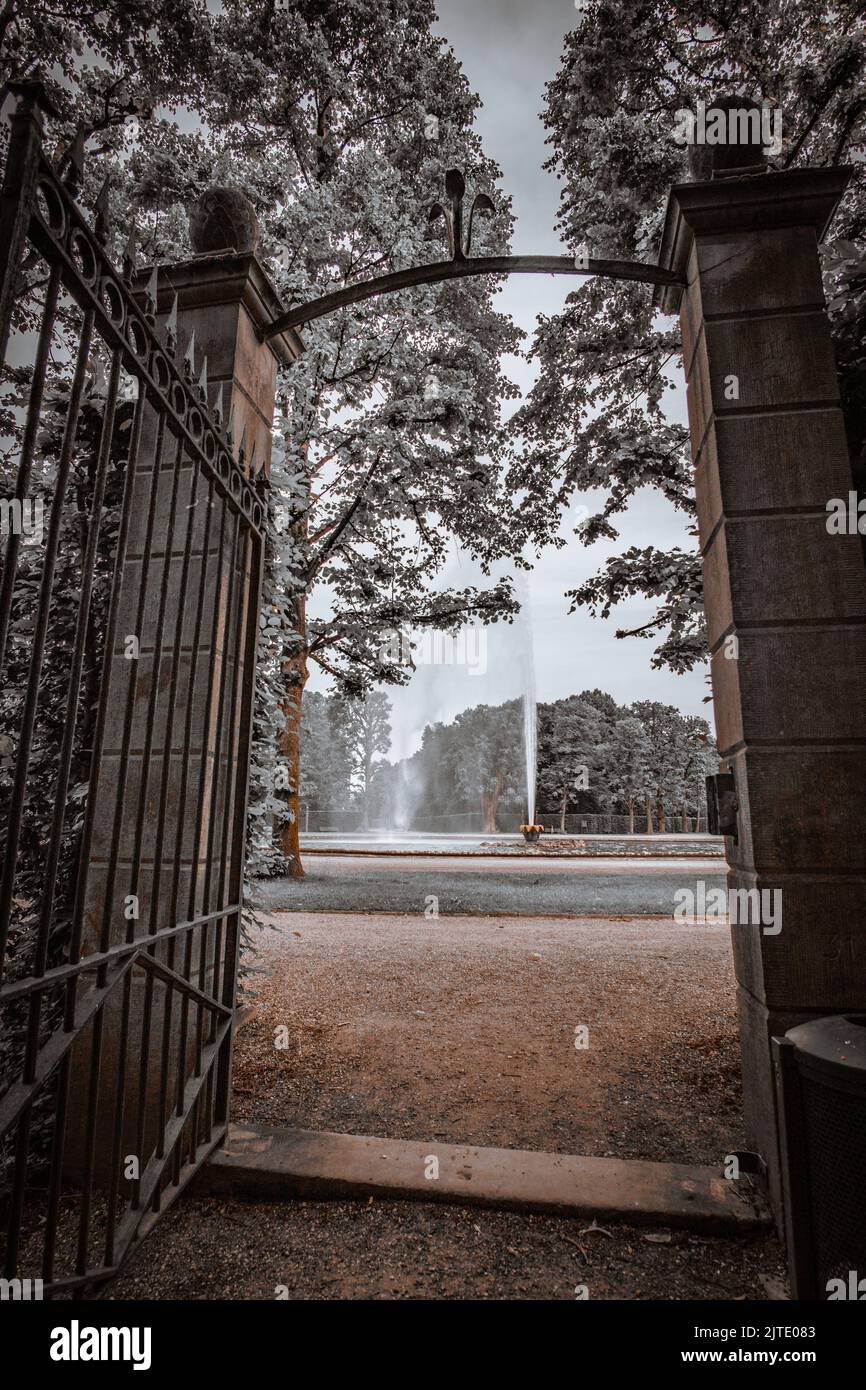 A vertical shot of a steel gate and a fountain inside Stock Photo - Alamy