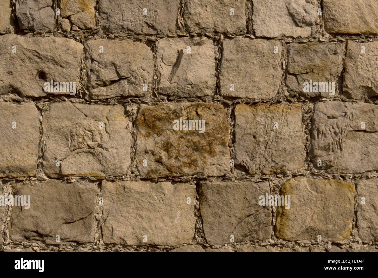 Close up detail of old ancient medieval castle wall with massive masonry stone bricks to use as ...