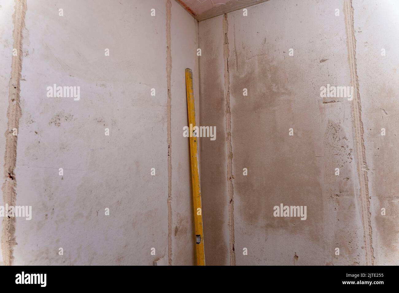 leveling the walls with plaster using lighthouses Stock Photo - Alamy