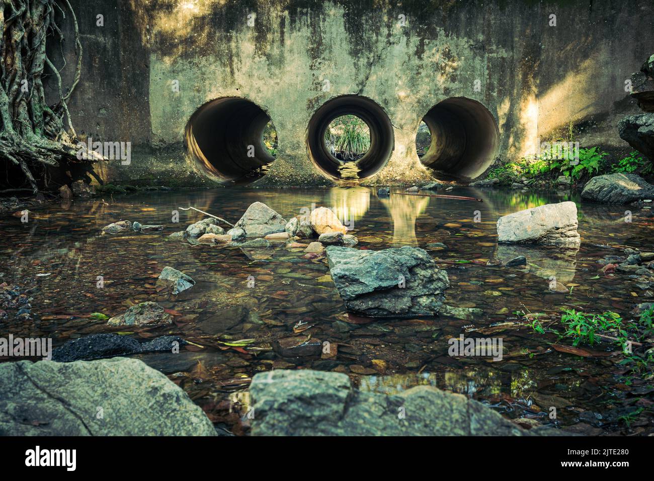 An urban landscape showing drainage tunnels and reflections in water ...