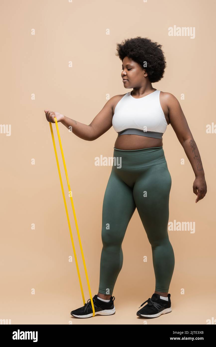 full length of curly african american plus size woman in sportwear ...